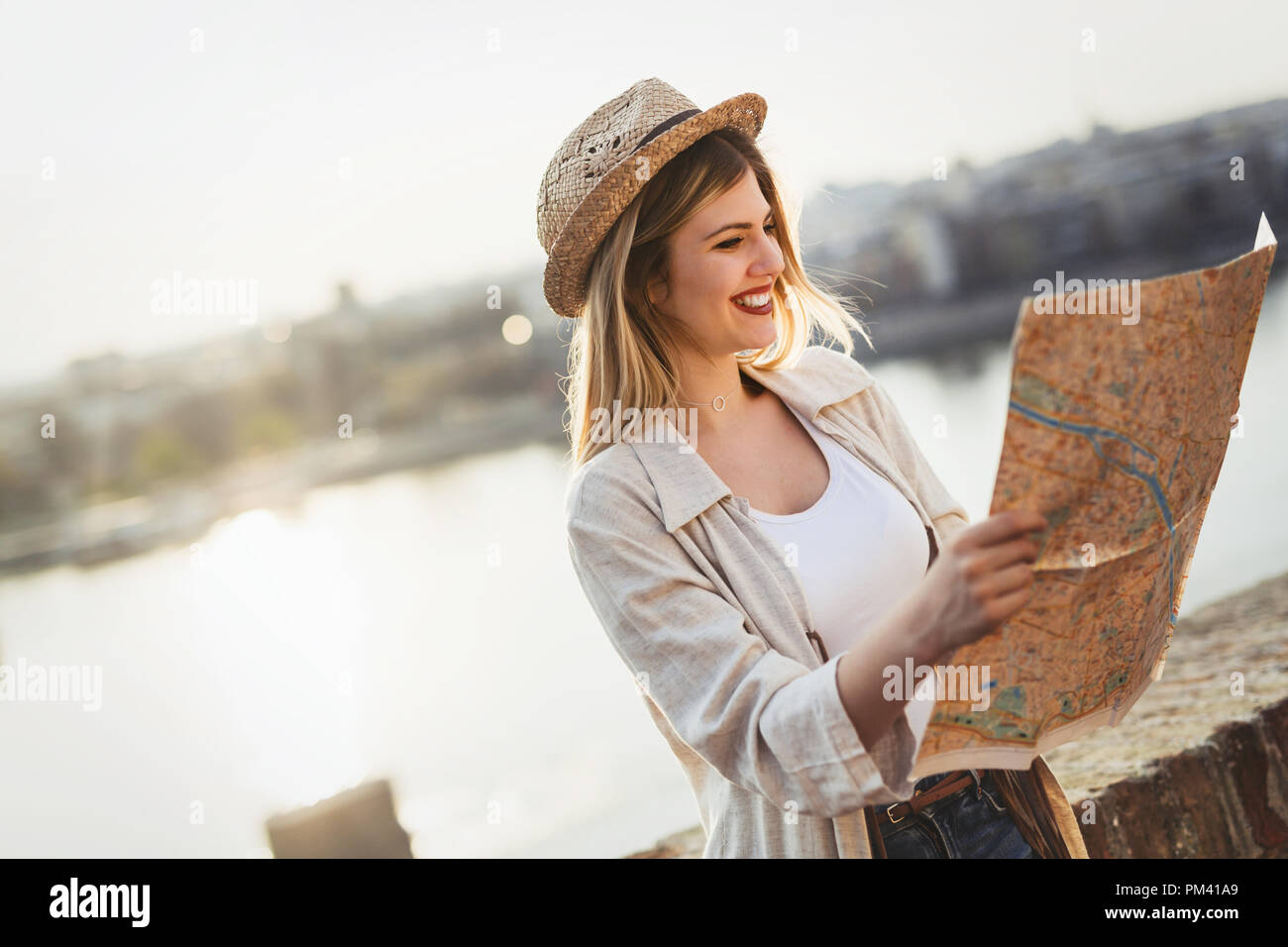 Tourist woman looking at map and exploring city Stock Photo - Alamy