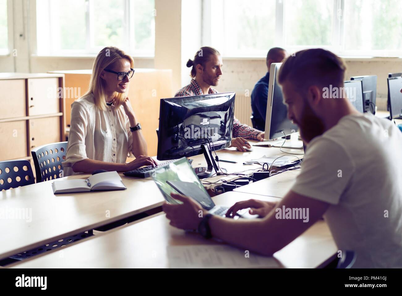 Just working day. Young modern colleagues in smart casual wear working ...