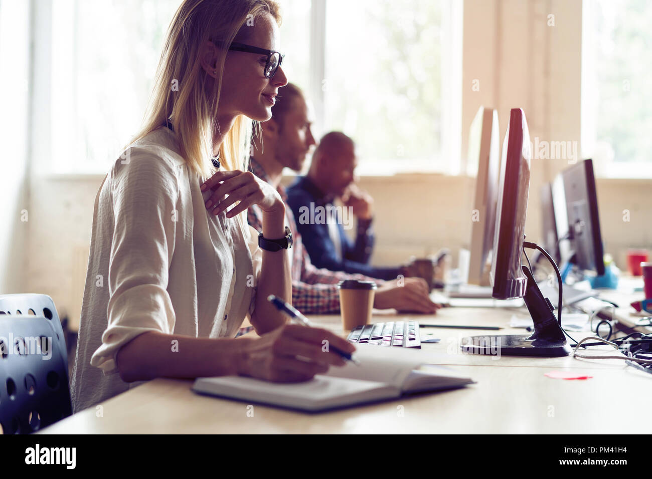 Just working day. Young modern colleagues in smart casual wear working ...