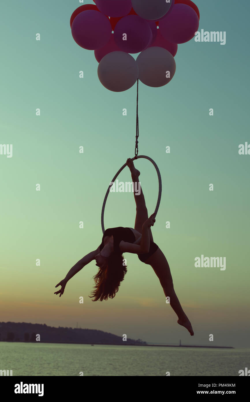 Acrobat girl doing acrobatic tricks on a circle at sunset Stock Photo ...
