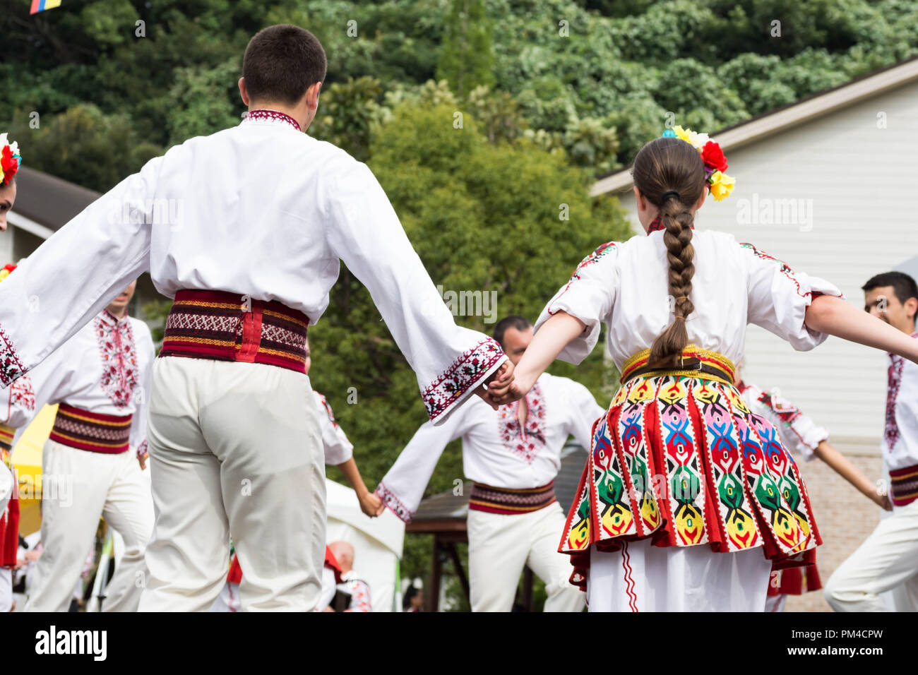 Bulgarian dancers in traditional clothes form a circle while dancing ...