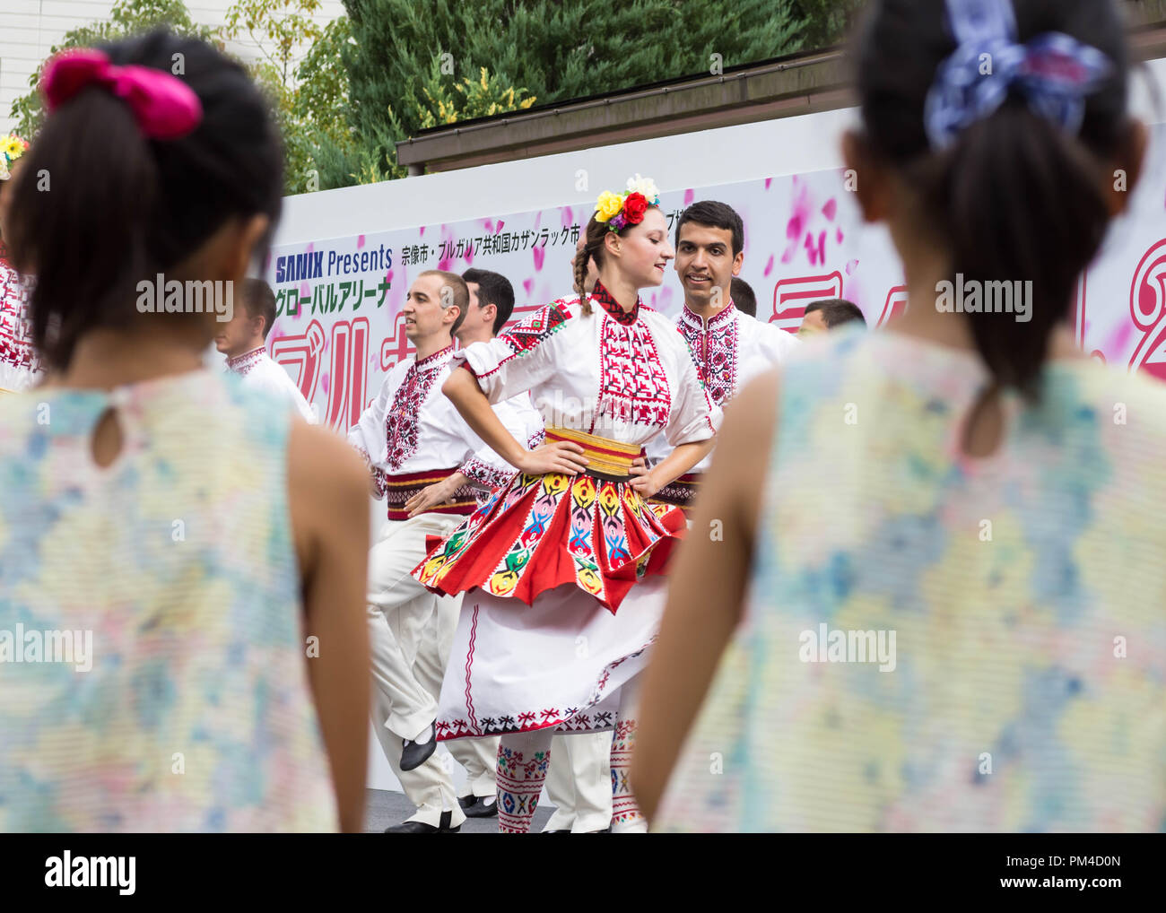 Two kids watching Bulgarian dancers in traditional clothes dancing ...