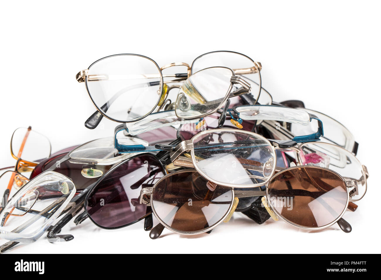 Old used eye reading glasses speclacles stacked in a pile on a white ...