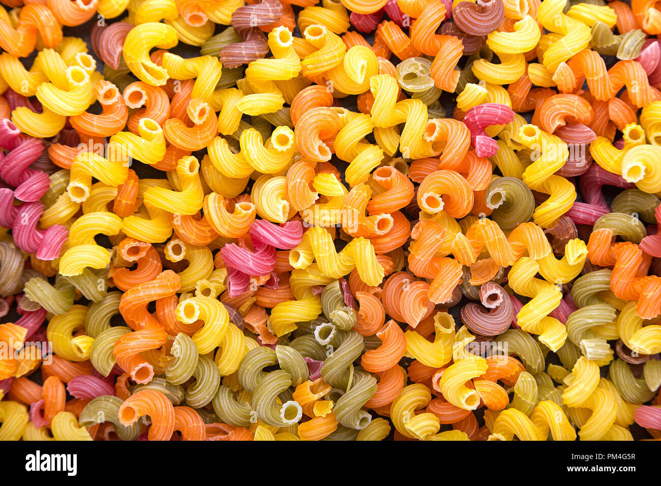 a scattered colored pasta, not cooked, background for recipe Stock ...