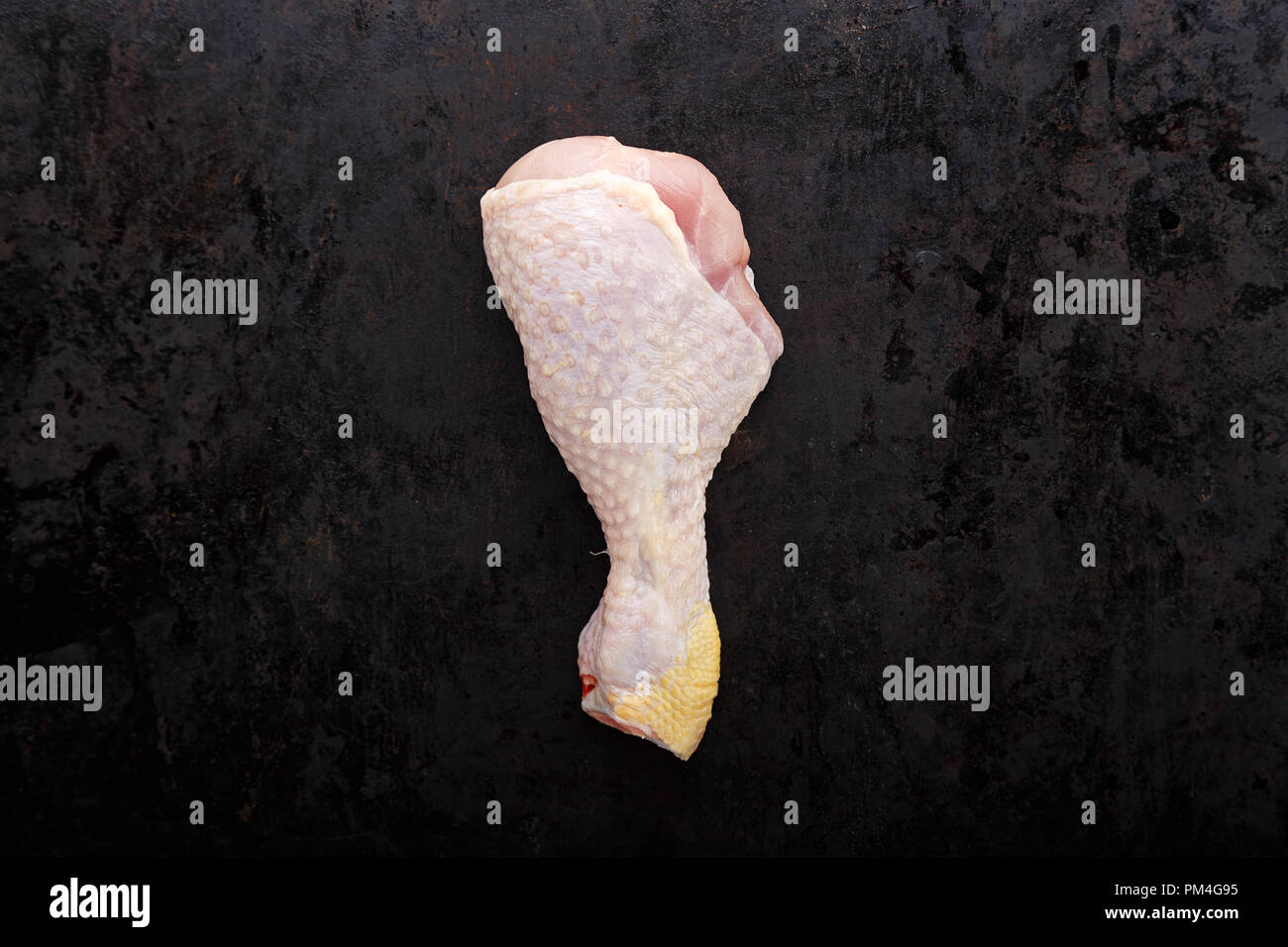 raw chicken leg on a black slate board Stock Photo - Alamy