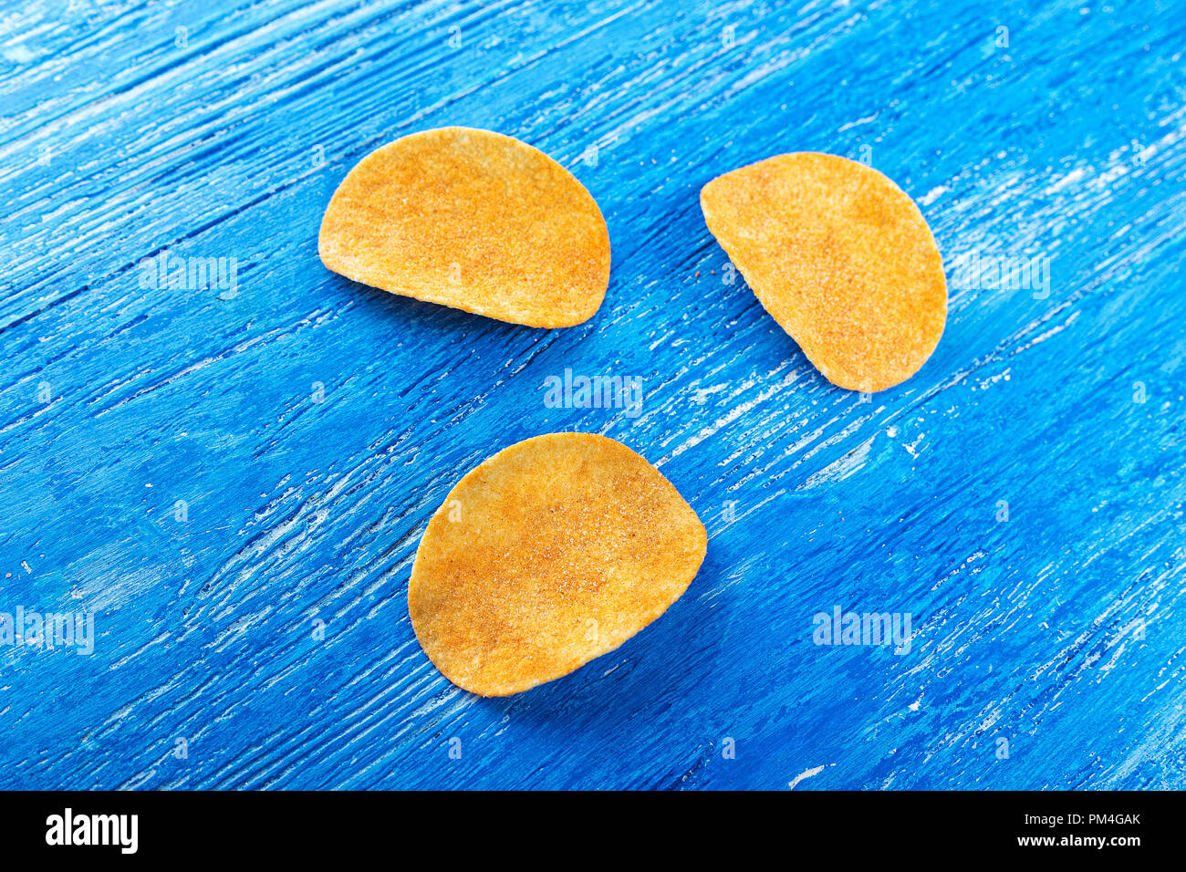 potato chips on a blue wooden background, cold snack, unhealthy eating ...