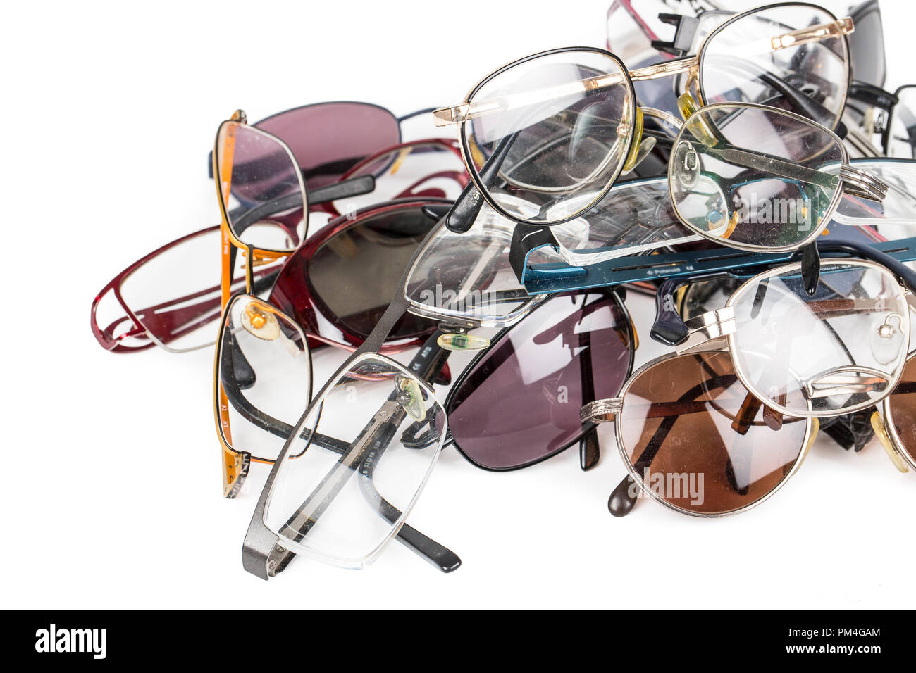Old used eye reading glasses speclacles stacked in a pile on a white ...