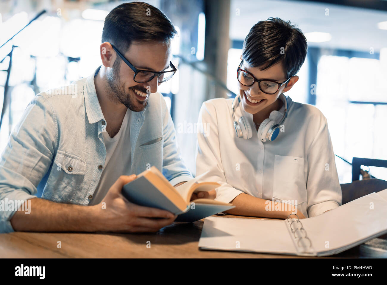 Happy couple studying in library Stock Photo - Alamy