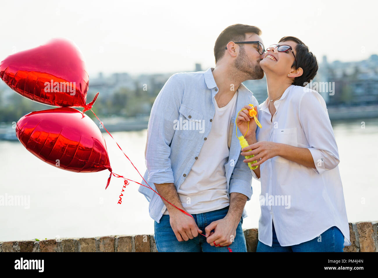 Couple in love cuddling while enjoying beautiful urban sunset together ...