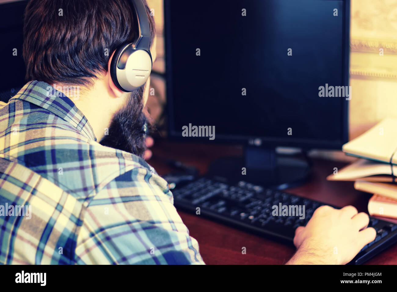 male behind computer with headphones Stock Photo - Alamy