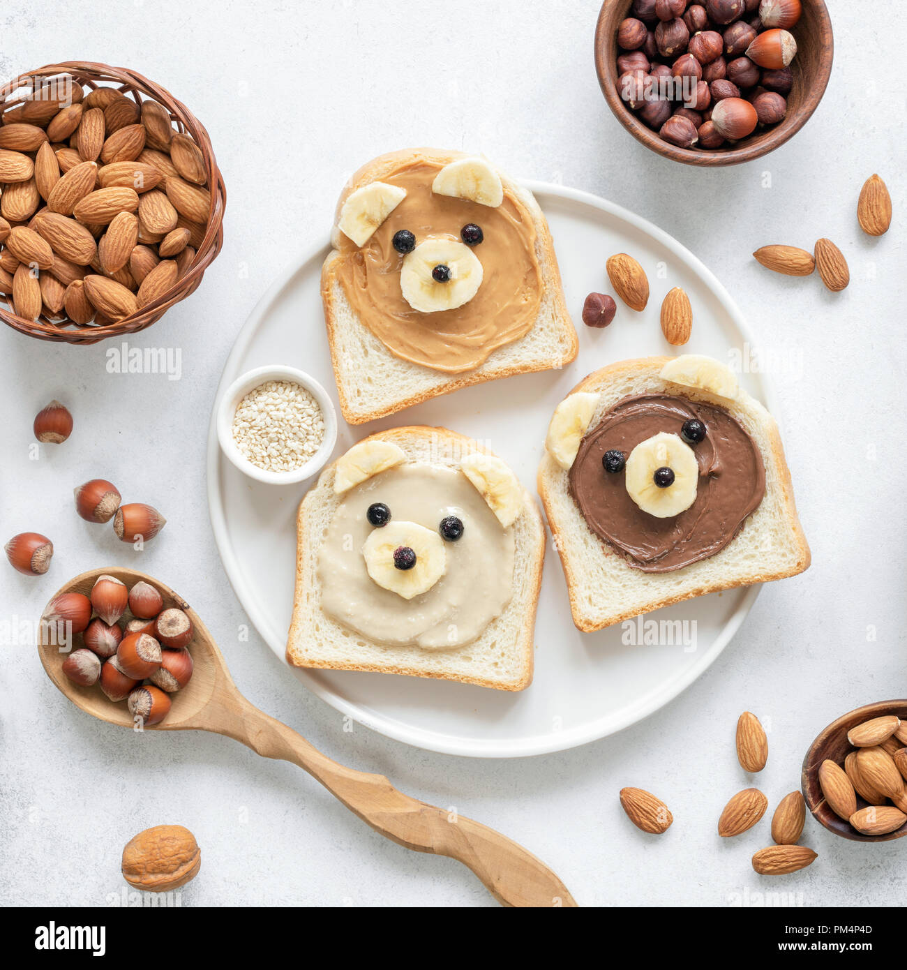 Nut butter toast in shape of cute funny bear for kids served on a white ...