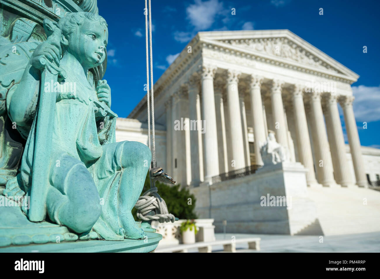 Copper green cherub holding sword and scales of justice at the base of ...