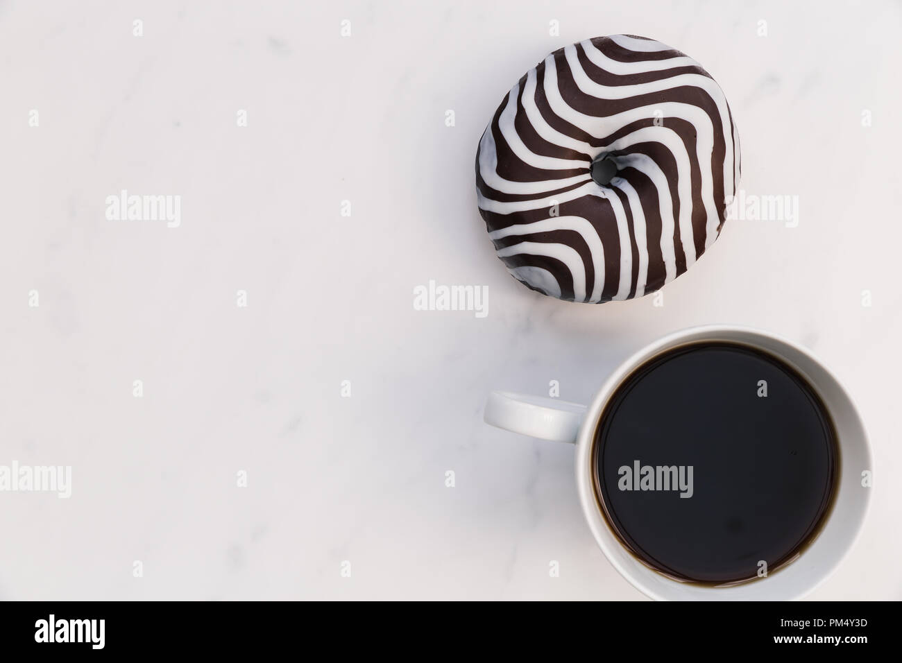 Striped donut and coffee cup on white background Stock Photo - Alamy