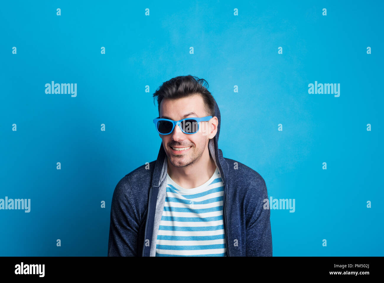 Portrait of a young man with blue sunglasses in a studio Stock Photo ...