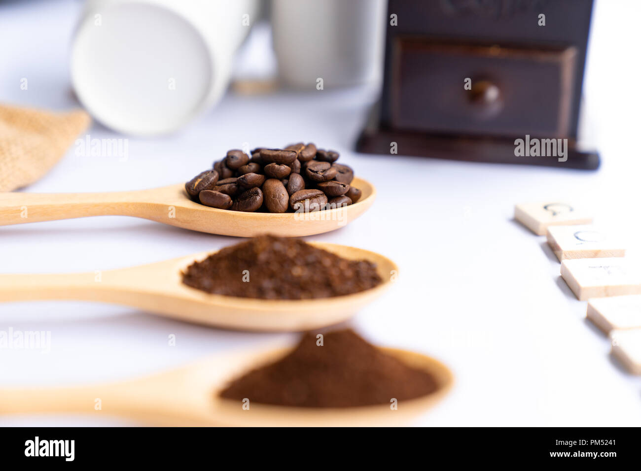wooden spoons filled with coffee bean and crushed ground coffee on ...