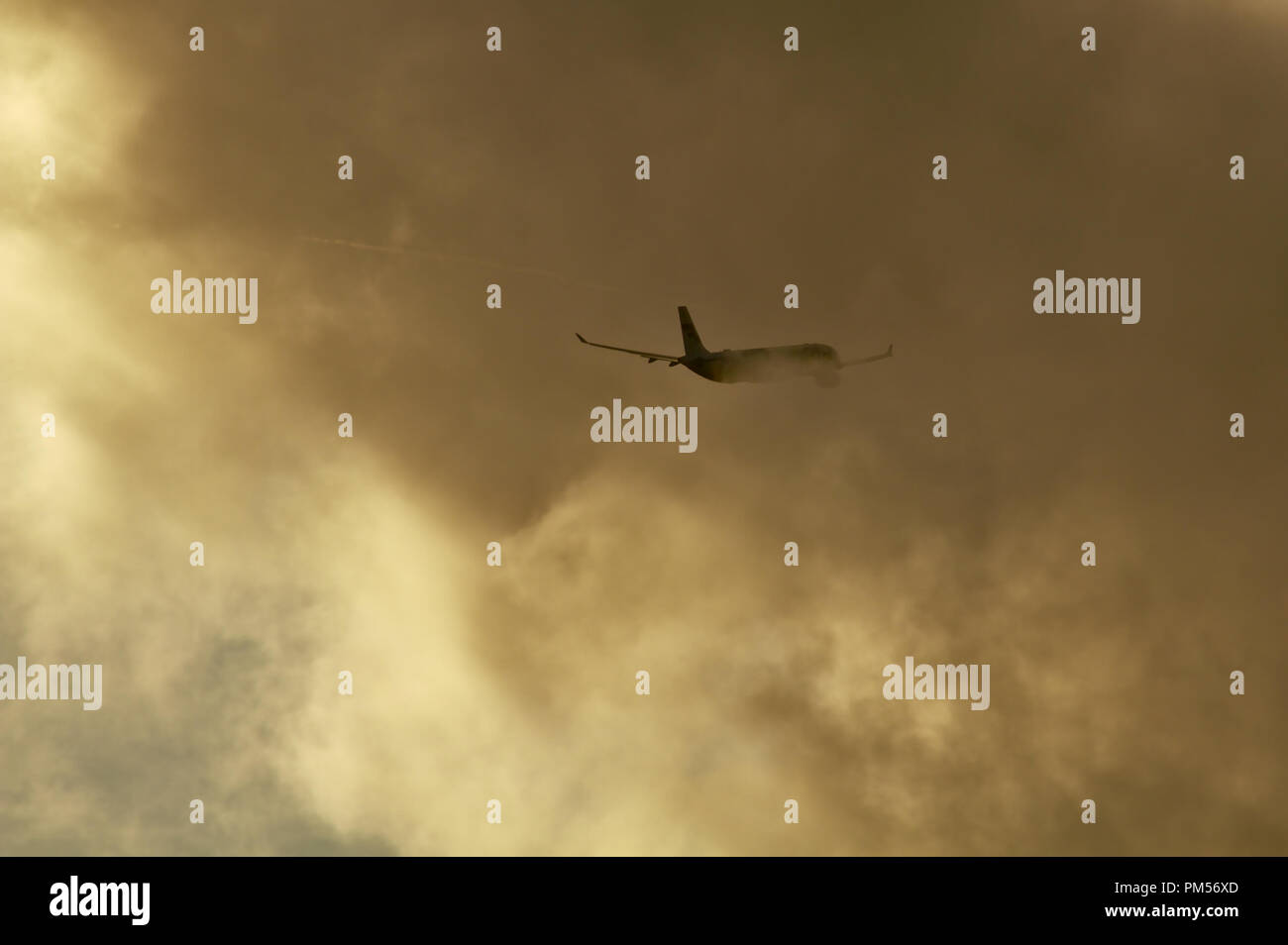 Commercial airplane disappears as it enters into the huge clouds Stock ...
