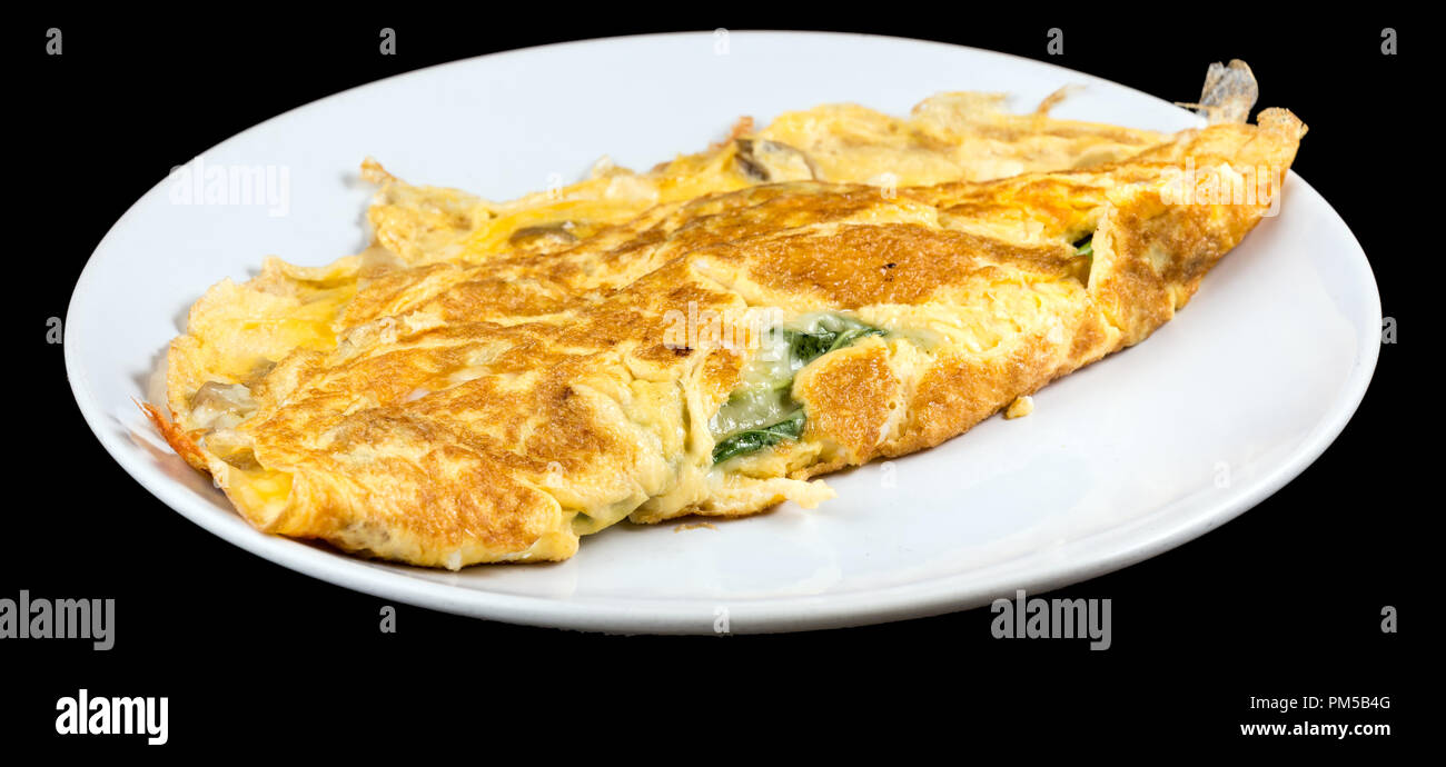 Omelet with organic spinach, cheese and mushrooms isolated on black ...