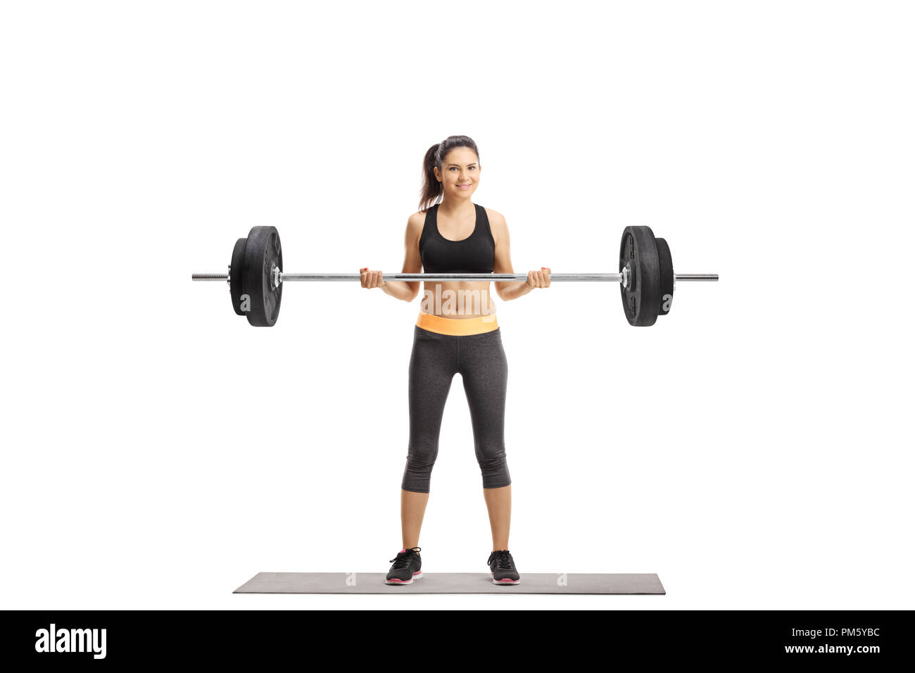 Young athletic female lifting a barbell isolated on white background ...