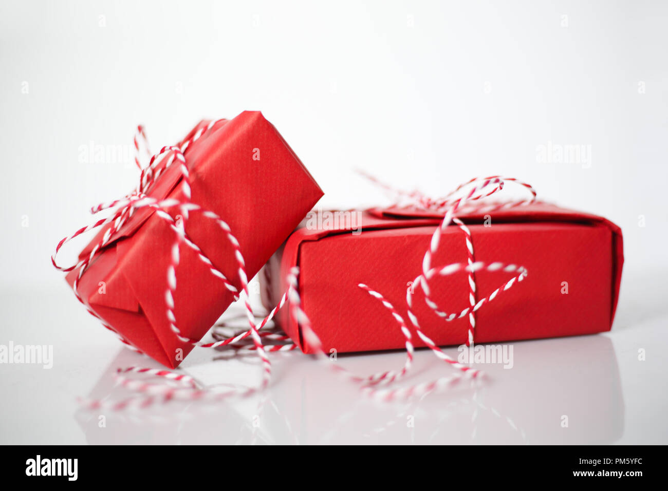 Christmas gift boxes wrapped in red paper and bow of dtriped rope on ...