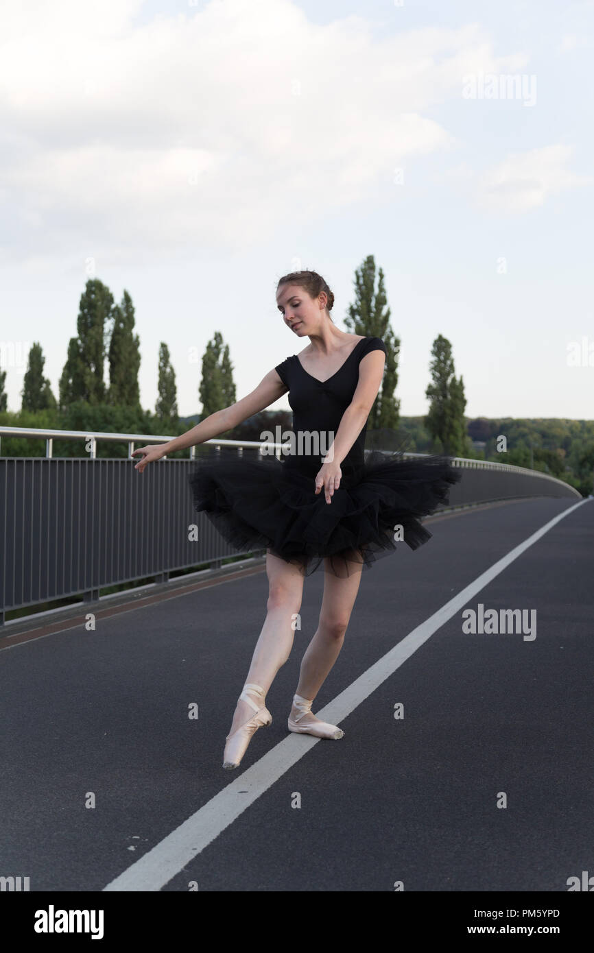 Ballet dancer dancing on road. Full length shot. Front facing Stock ...