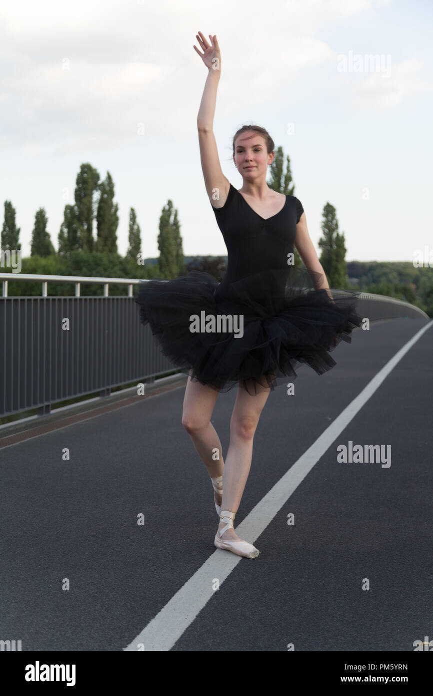 Ballet dancer dancing on road. Full length shot. Front facing Stock ...
