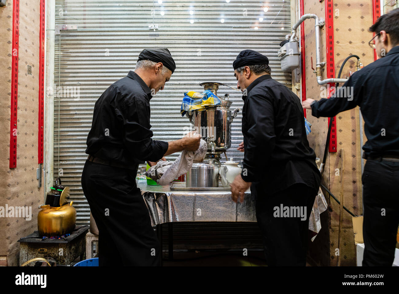 Iranian men preparing tea at a makeshift stall in the bazaar in Ardabil ...