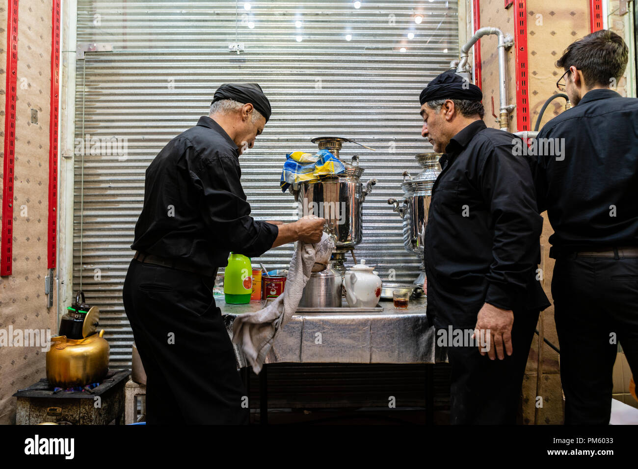 Iranian men preparing tea at a makeshift stall in the bazaar in Ardabil ...