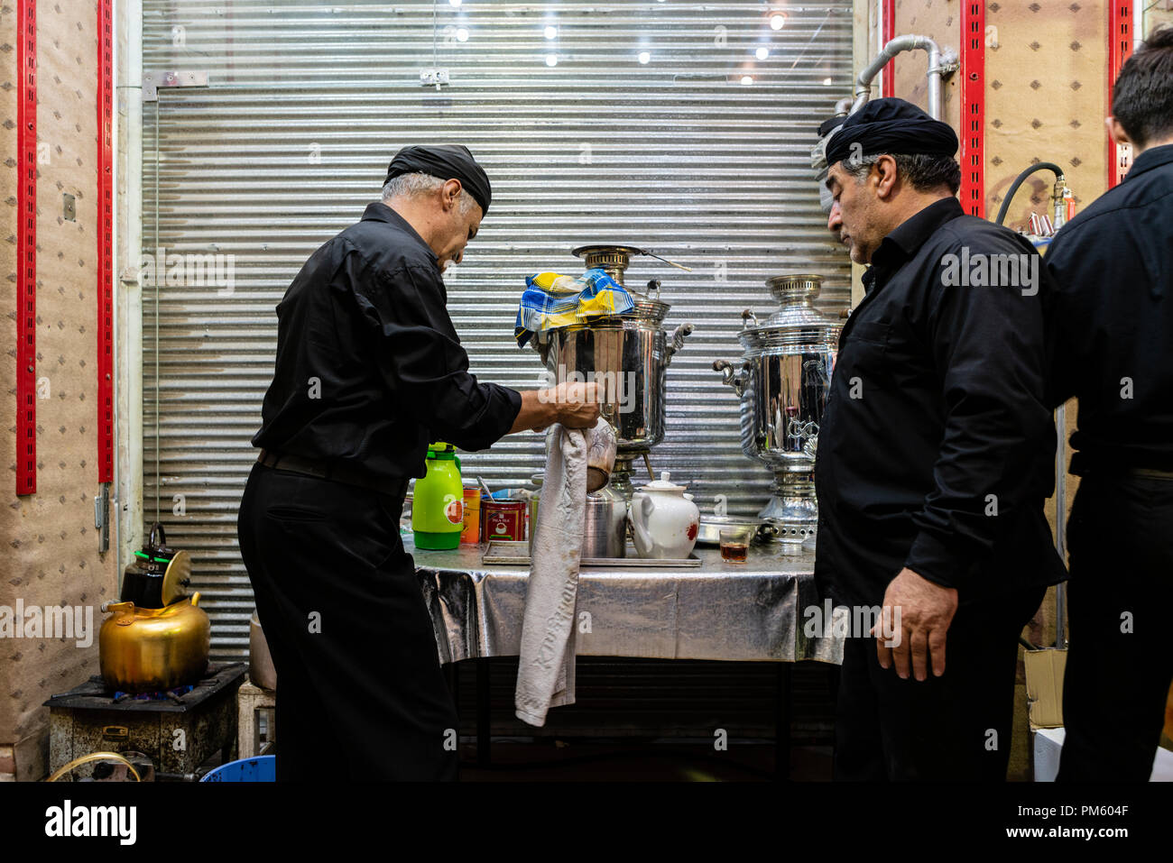 Iranian men preparing tea at a makeshift stall in the bazaar in Ardabil ...