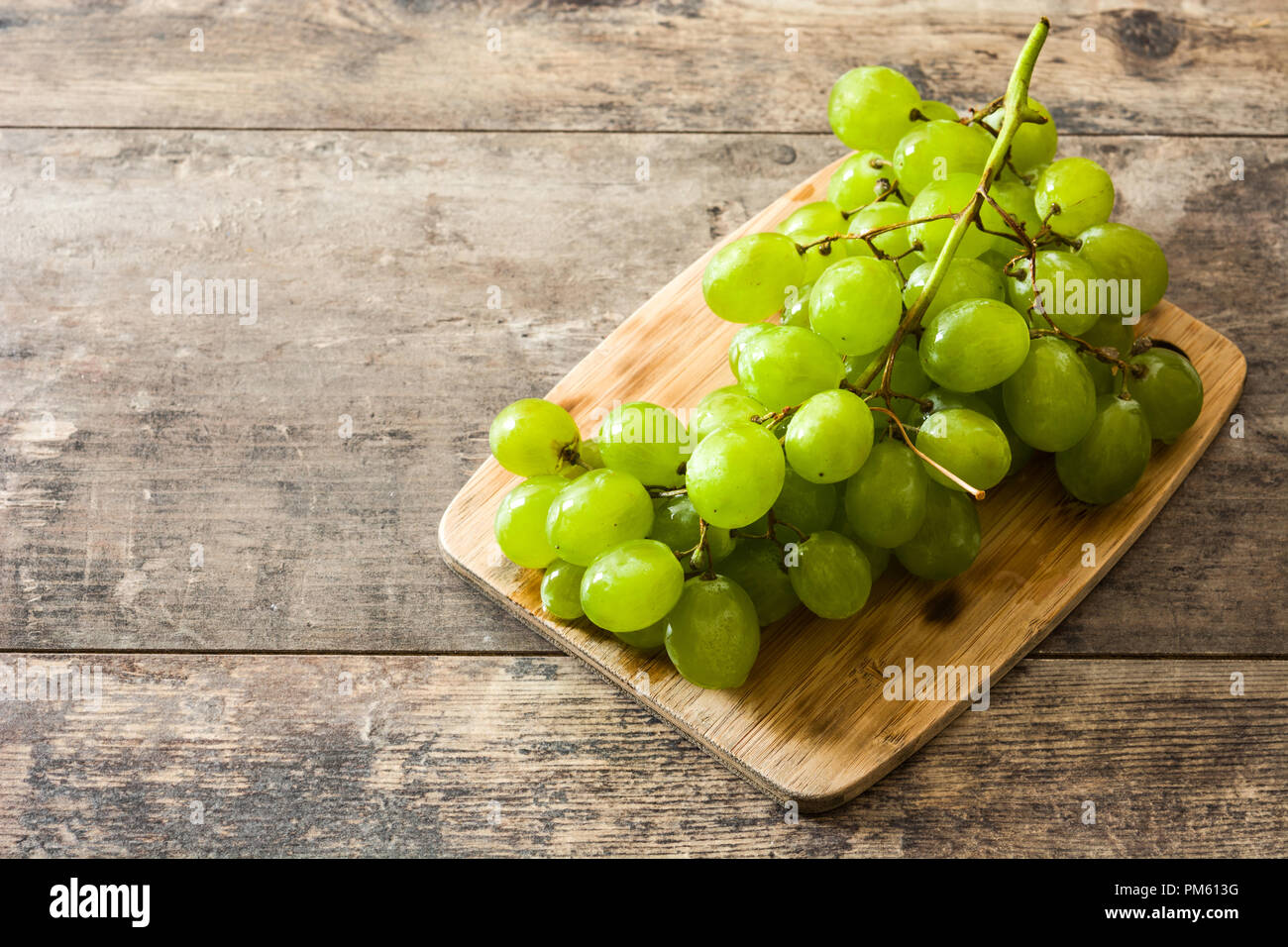 Green grapes on wooden table. Copyspace Stock Photo - Alamy