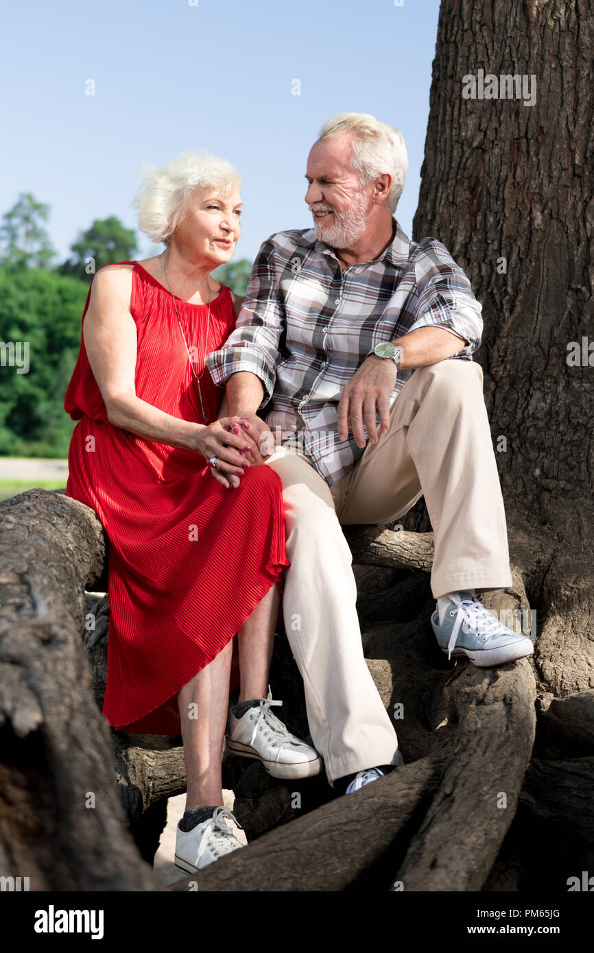 Peaceful aged people sitting on the tree and talking Stock Photo - Alamy