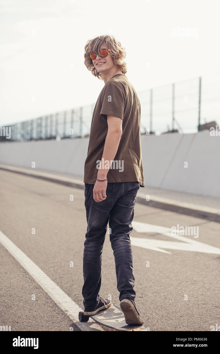 boy riding longboard on boardwalk, warm summer time Stock Photo - Alamy