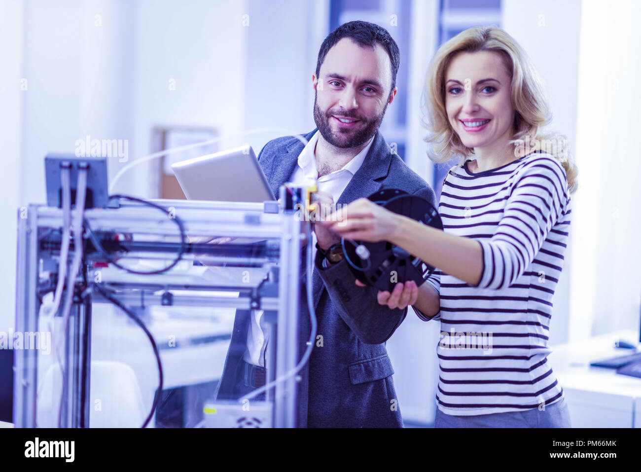 Positive delighted workers looking straight at camera Stock Photo - Alamy