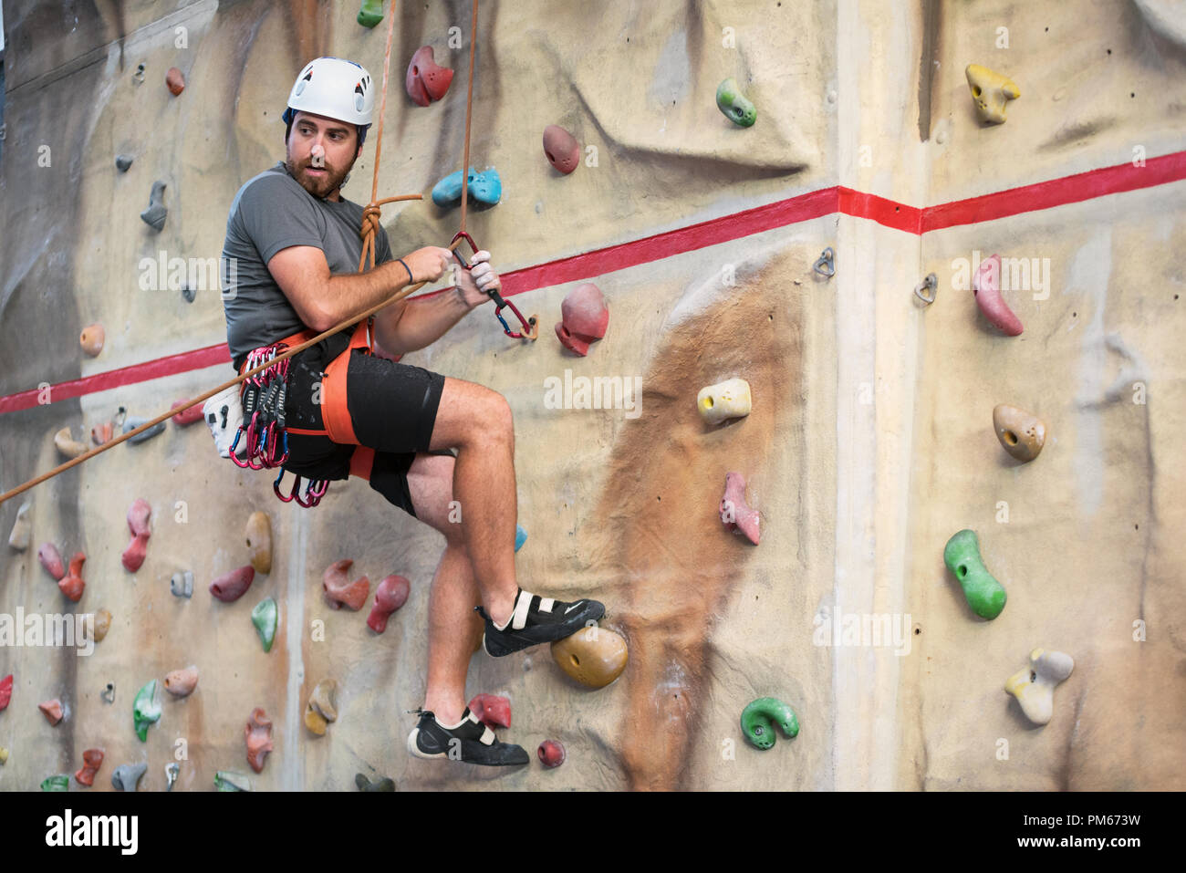 Man climber on artificial climbing wall Stock Photo - Alamy