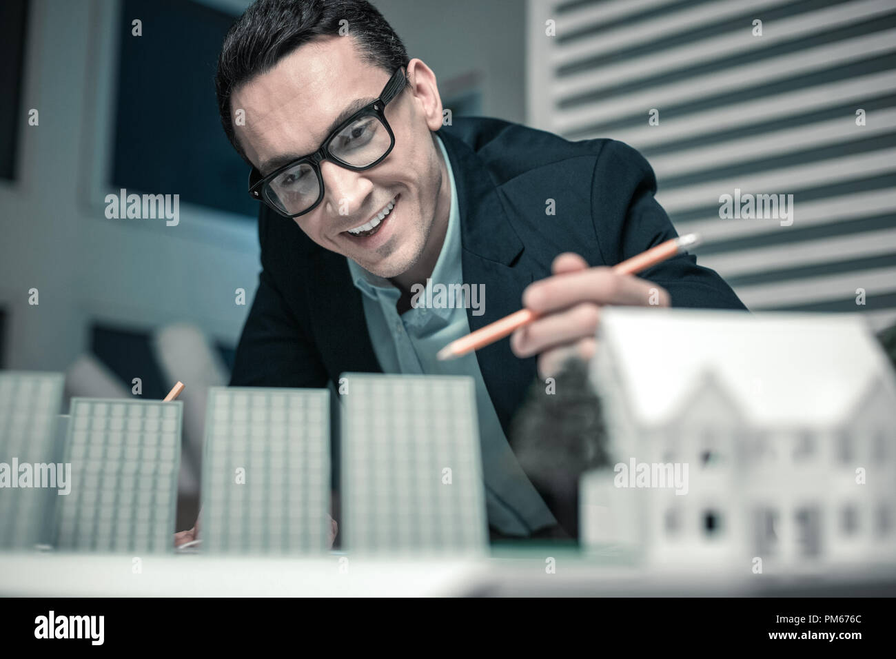Smiling young man pointing at beautiful layout Stock Photo - Alamy