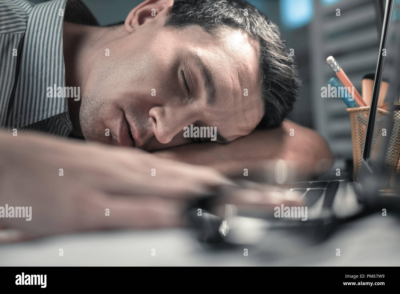 Portrait of sleepy worker laying on a table Stock Photo - Alamy