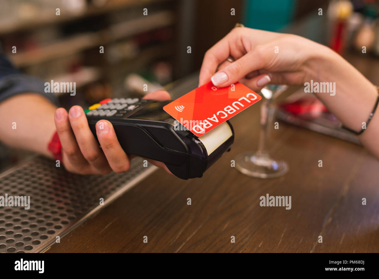 Close up of the client paying by card in the bar Stock Photo - Alamy