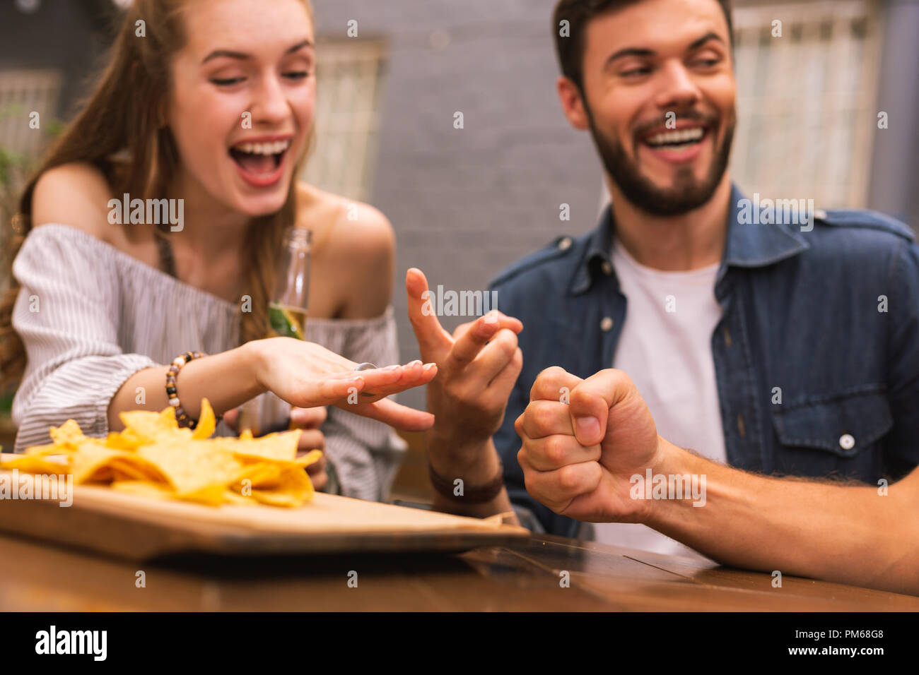Emotional friends laughing while playing games in the bar Stock Photo ...