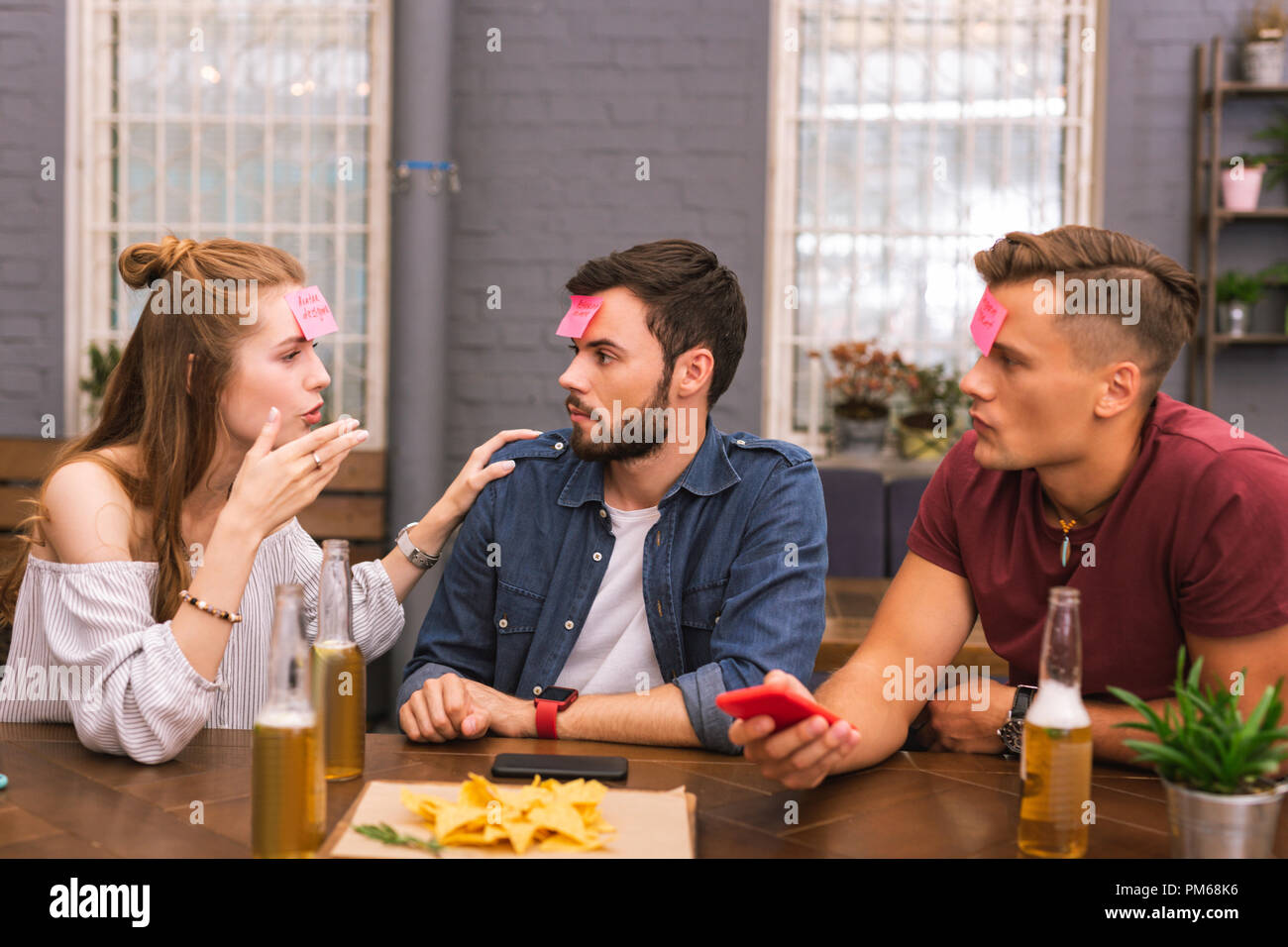 Thoughtful people looking at their friend while guessing the word Stock ...