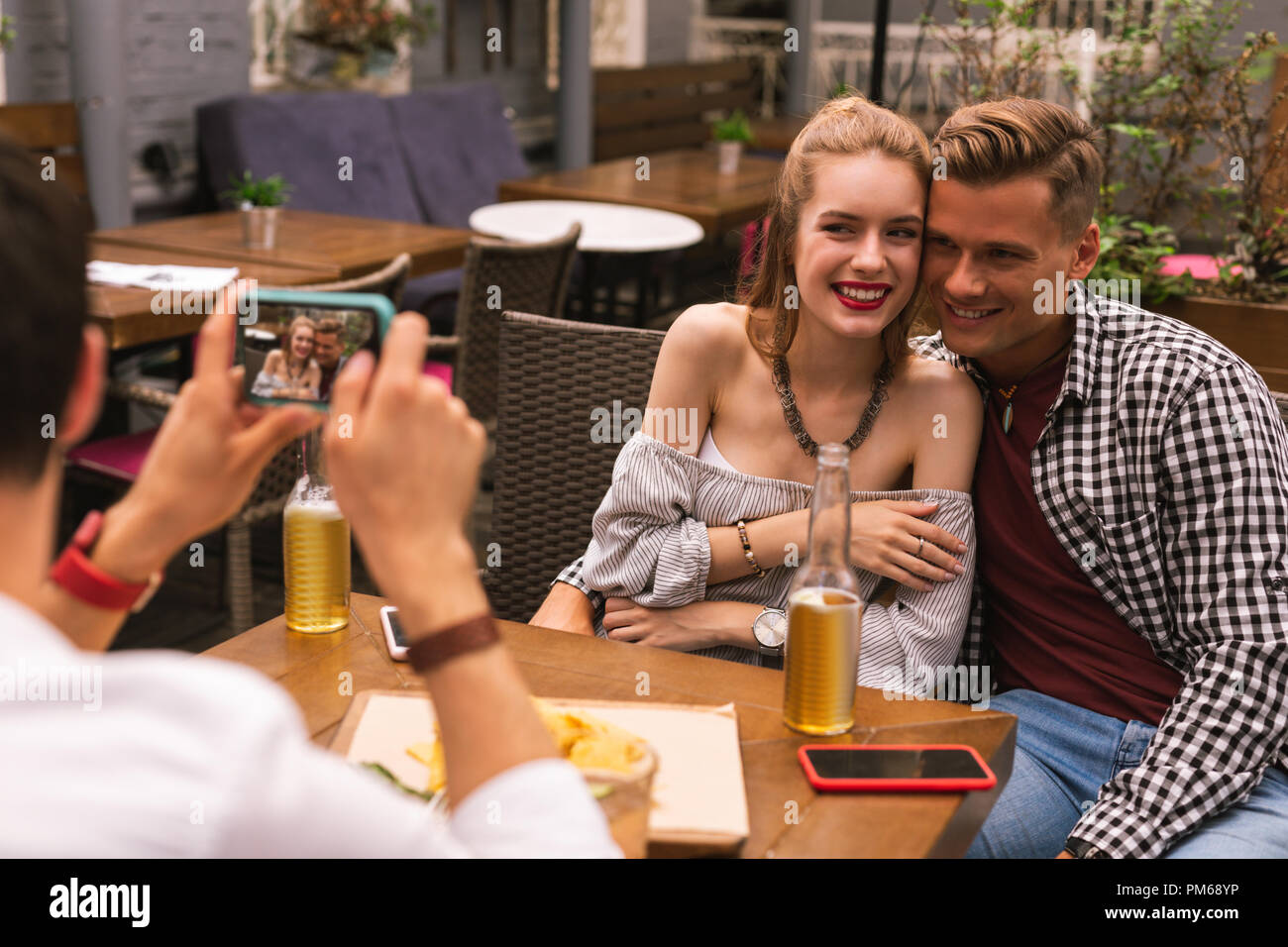 Cute young couple smiling while being photographed by friend Stock ...