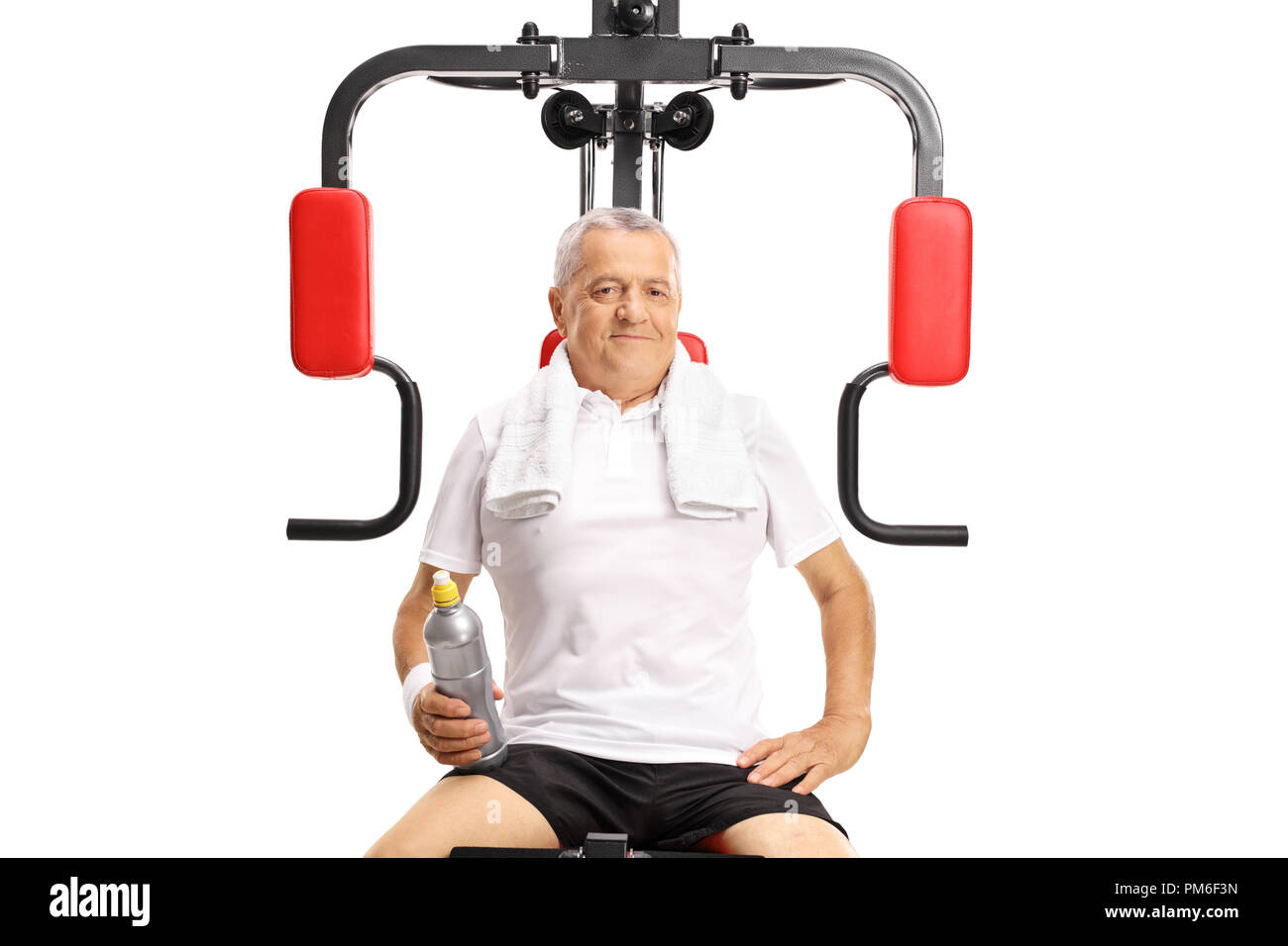 Elderly man sitting on an exercise machine isolated on white background ...