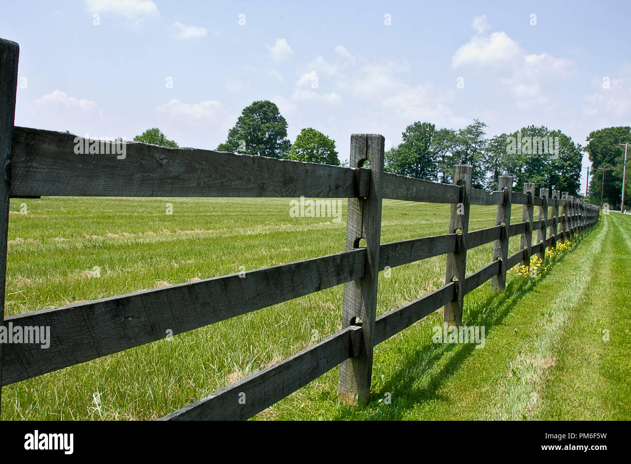 Trailing wood split-rail fence bordering farmland in country Stock ...
