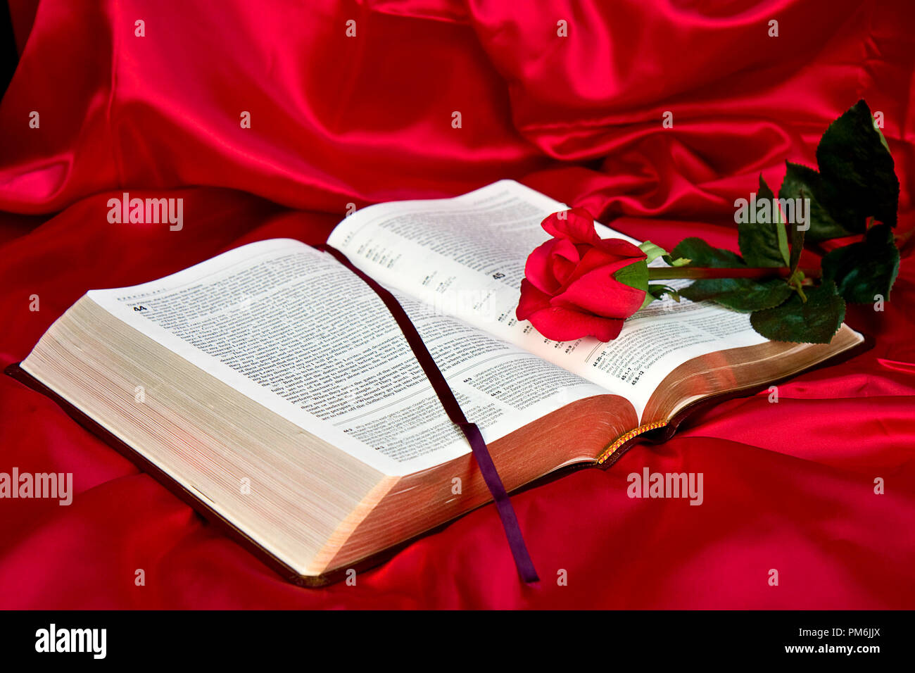 Bible opened up with worn gold on pages isolated on black background ...