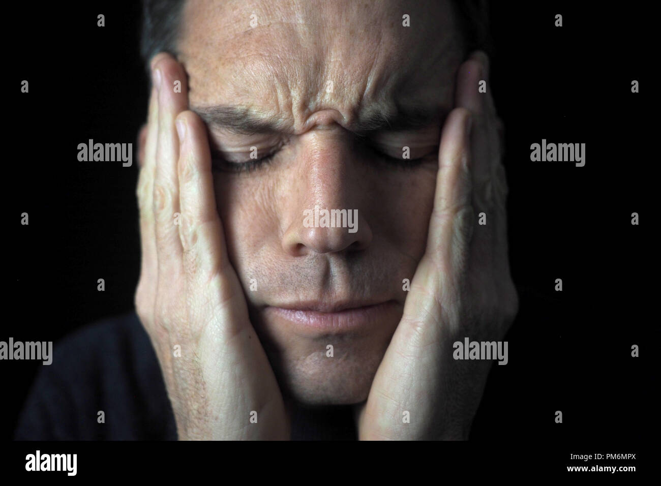 Portrait of man on black background, stressed, hands on face Stock ...