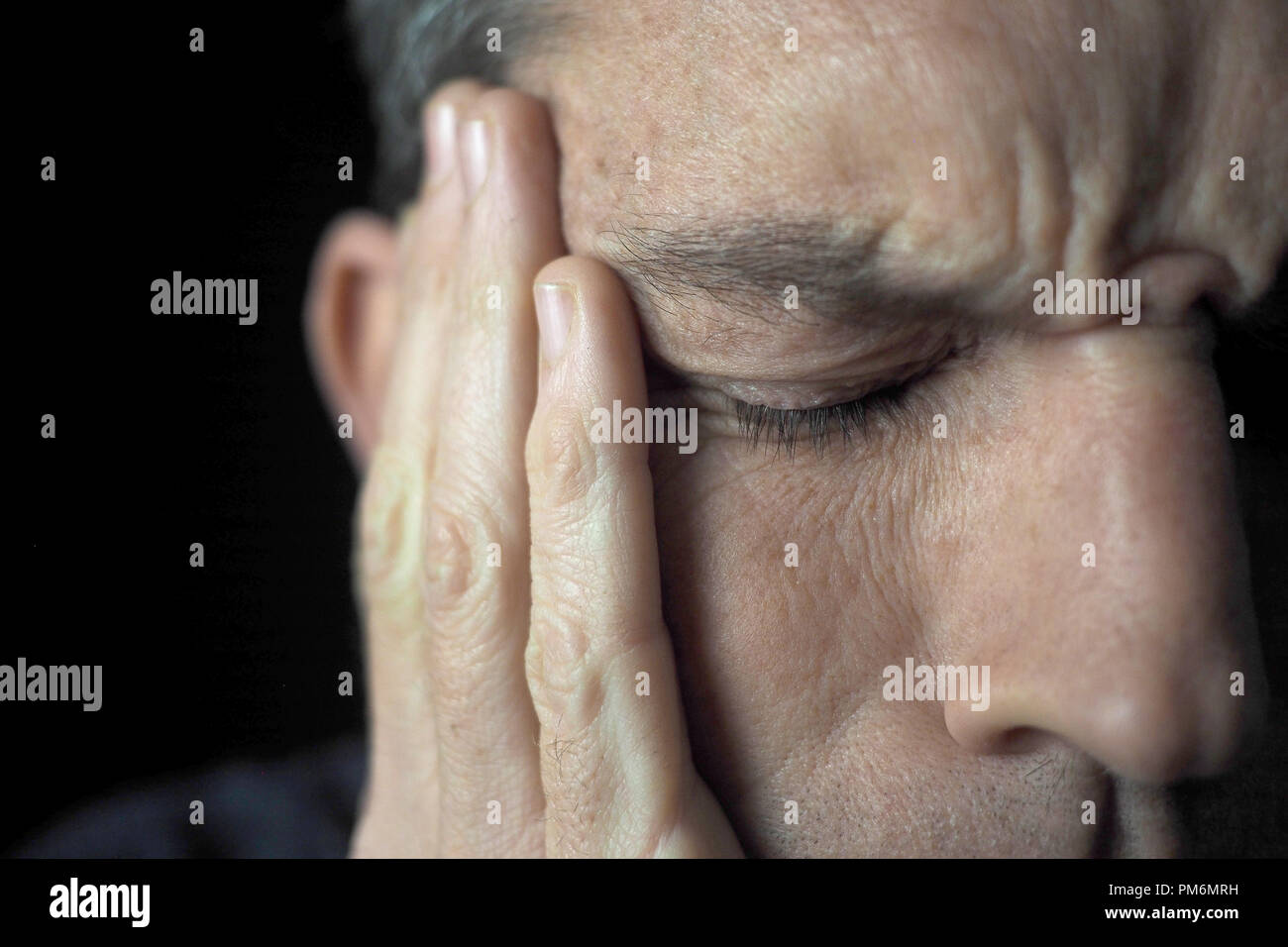Portrait of man on black background, stressed, hands on face Stock ...