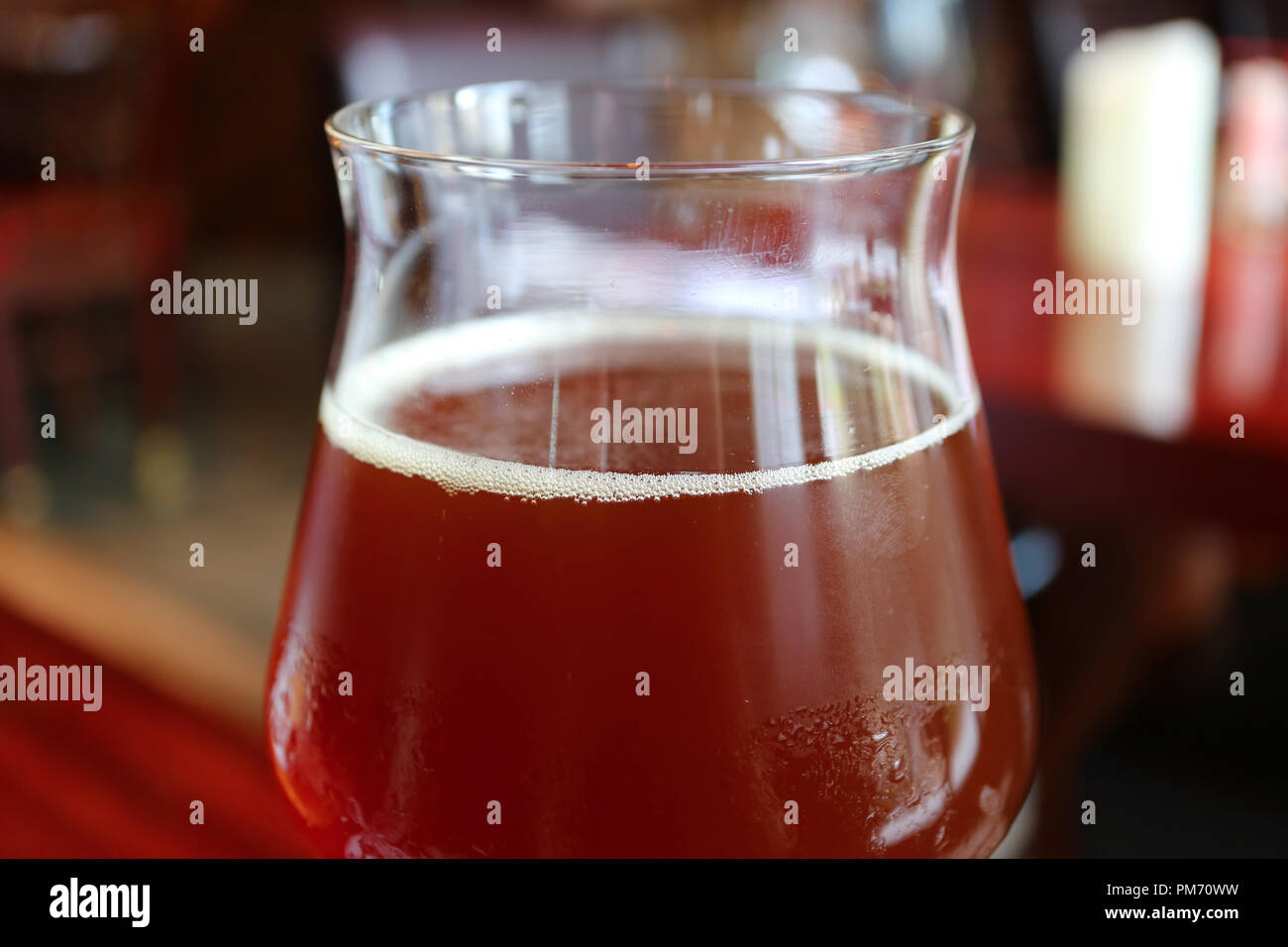 Closed up a glass of ruby color chilled craft beer Stock Photo - Alamy