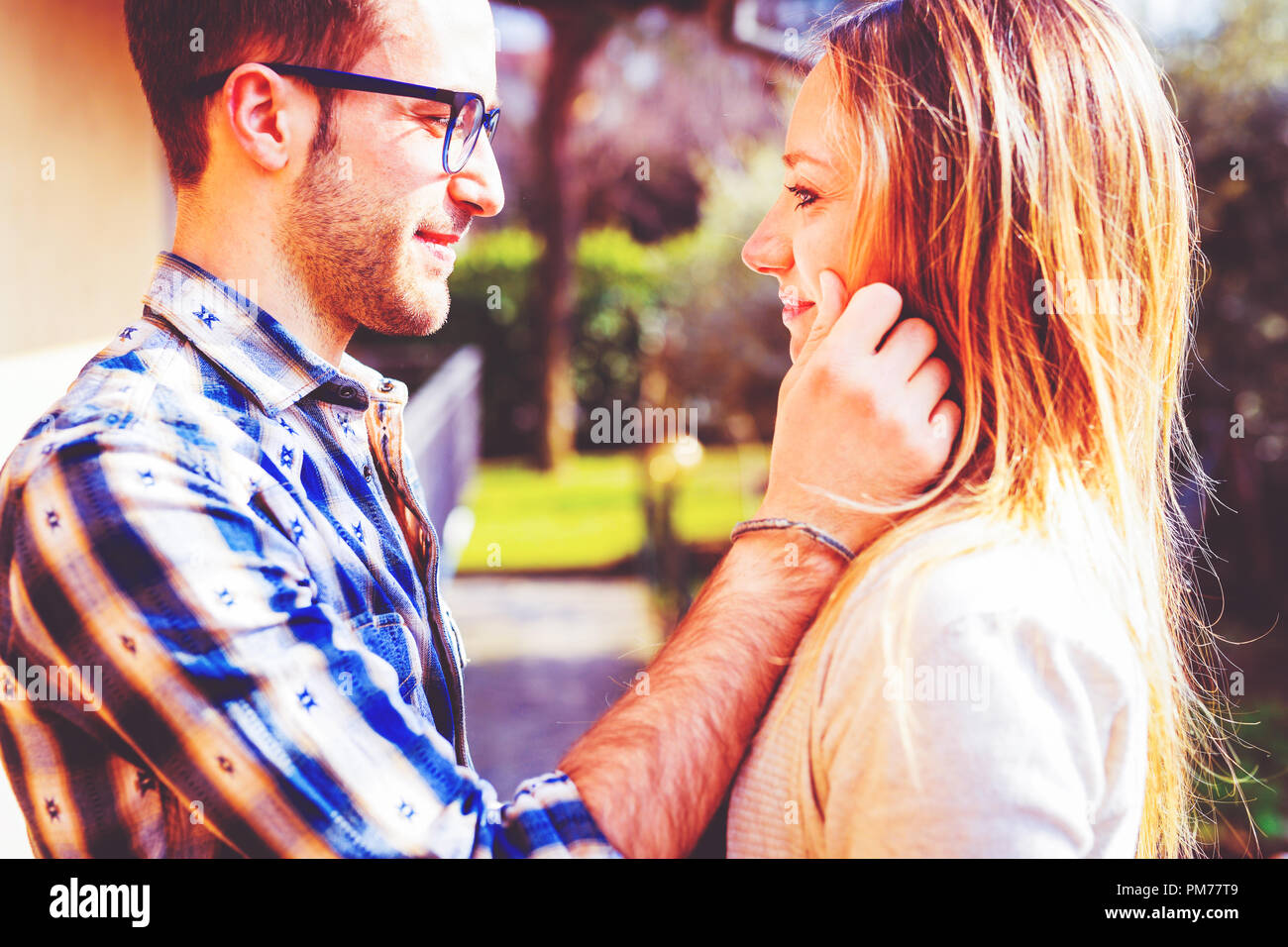 young couple in love outdoor back light looking in the eye serene ...