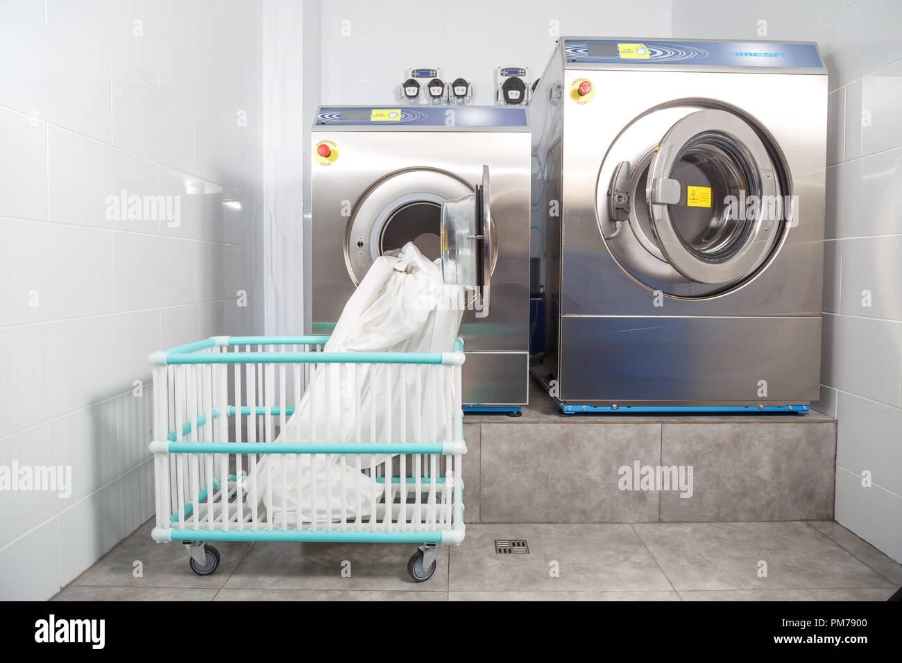 Washing machine overloaded with clothes and empty basket in laundry ...