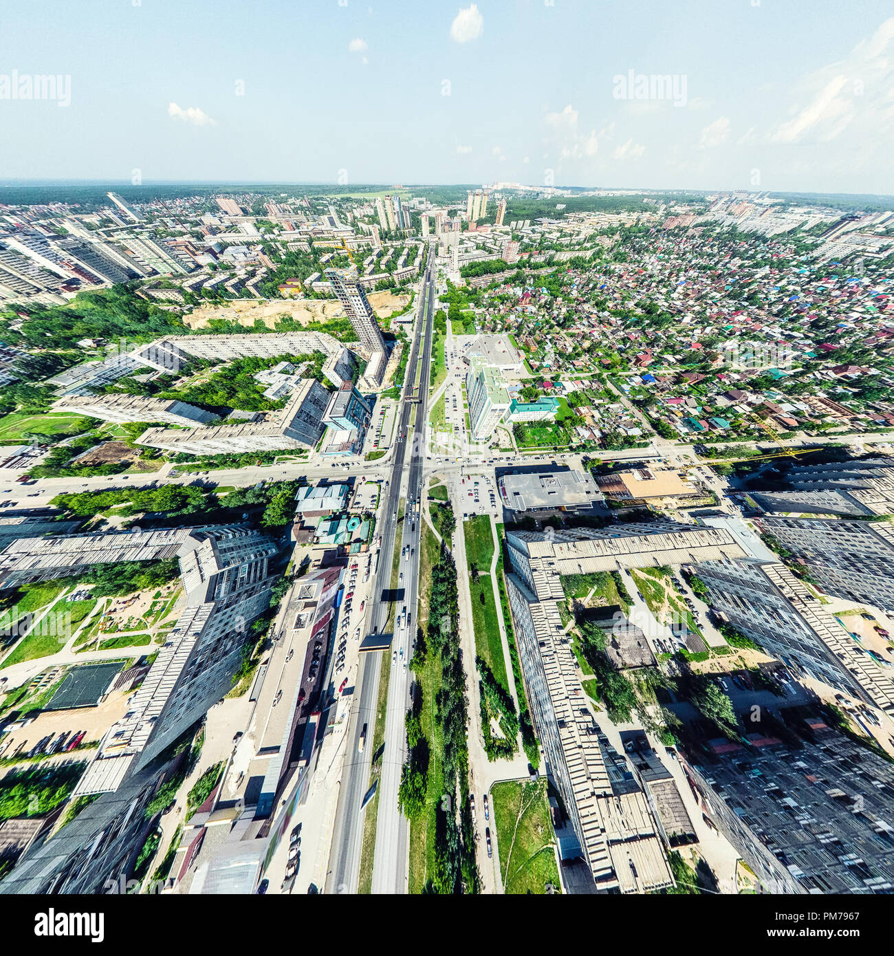 Aerial city view with crossroads and roads, houses, buildings, parks and parking lots. Sunny ...