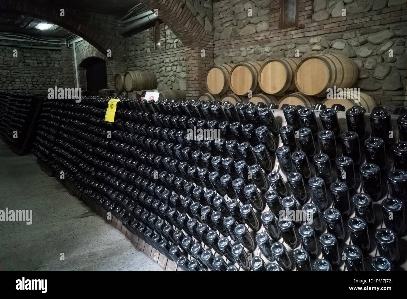 Ancient wine cellar with oak barrels and shelves with bottles of Stock ...