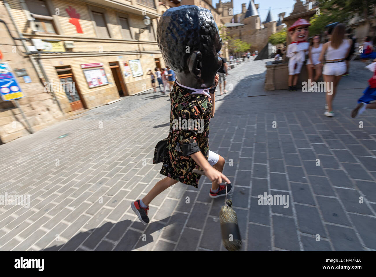 Cabezudos carrying a pig bladder, used to frighten children or young ...